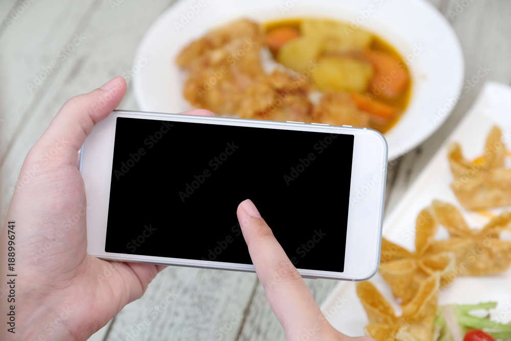 Hands using smart phone with blank screen over blur food background ...