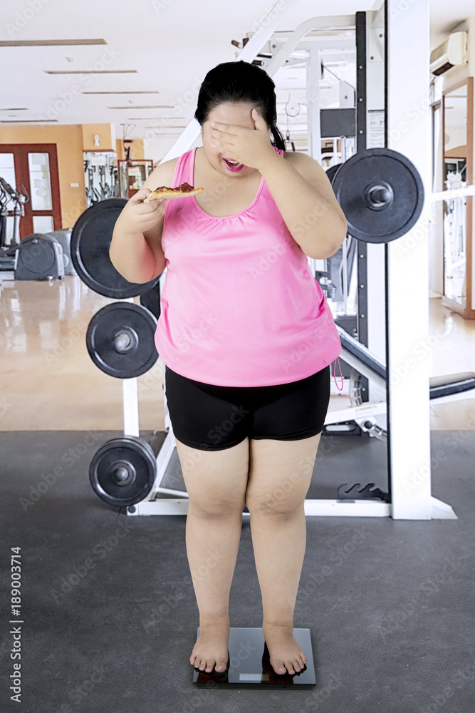 Fat woman with scales in the gym center Stock Photo | Adobe Stock