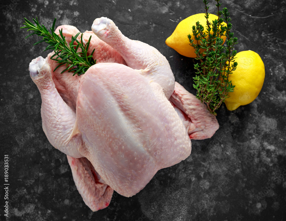 Whole raw Free range chicken in rustic background with rosemary leaf ...