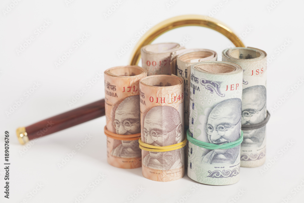 Rolls of Indian Currency Rupee Notes with magnifying glass Stock Photo ...