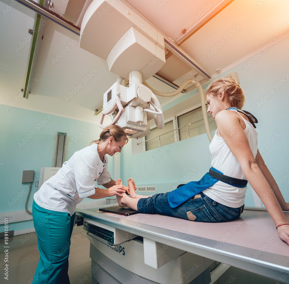 Radiologist and patient in a x-ray room. Classic ceiling-mounted x-ray ...