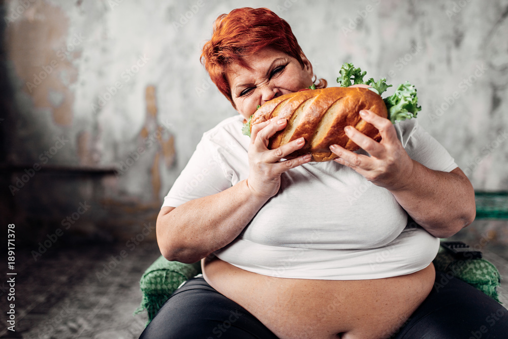Fat woman sits in chair and eats sandwich, bulimic Stock Photo | Adobe ...