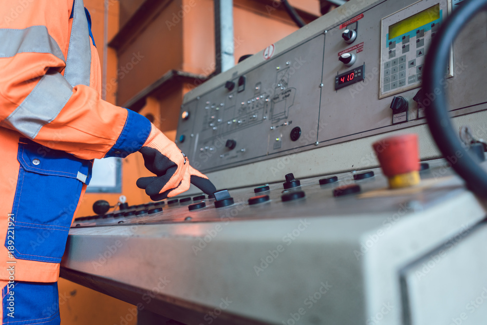 Operator in waste recycling facility operating garbage press Stock ...