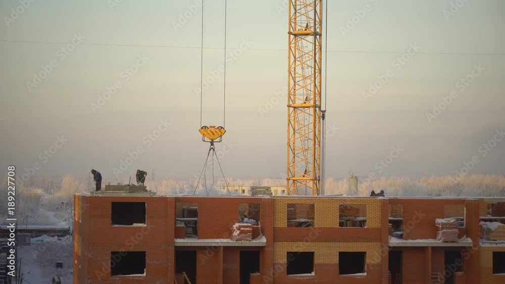 Construction site with workers of high-rise houses of brick. Workers ...