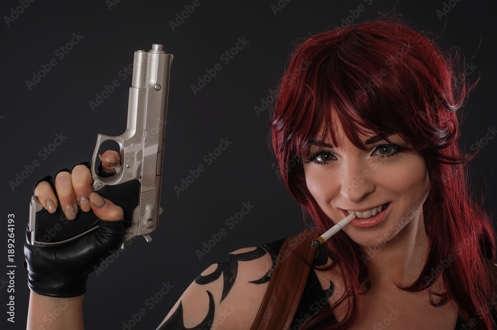 Beautiful redhead woman with gun against dark background Stock Photo ...