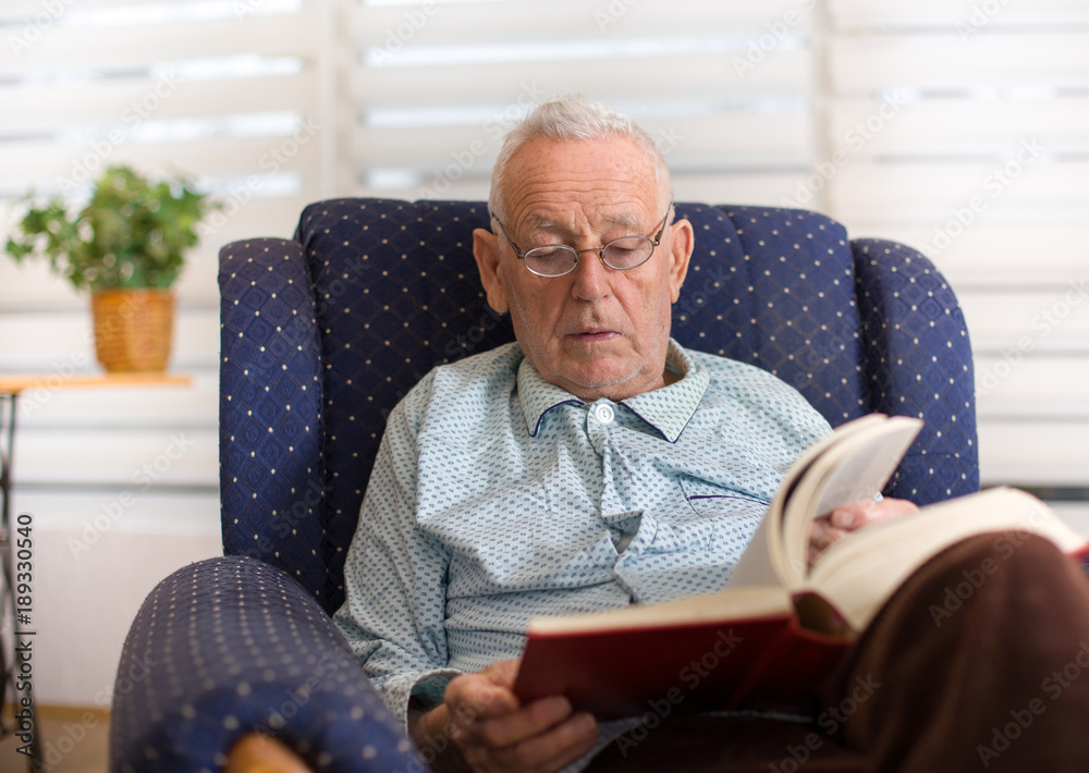 Old man reading book at home Stock Photo | Adobe Stock