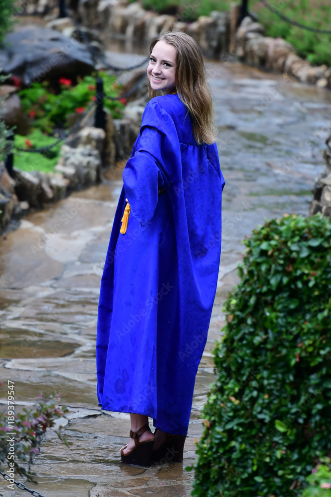 High School Senior in cap and gown posing in the rain at a botanical ...