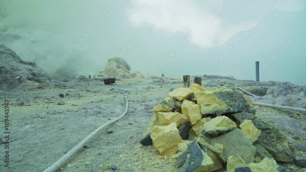 Extraction of sulfur in the crater of a volcano. Sulfur gas, smoke ...