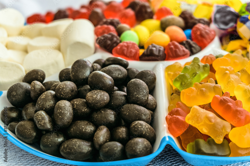 Set of sweet loose candies in a tray. Heaps of peanuts in chocolate ...