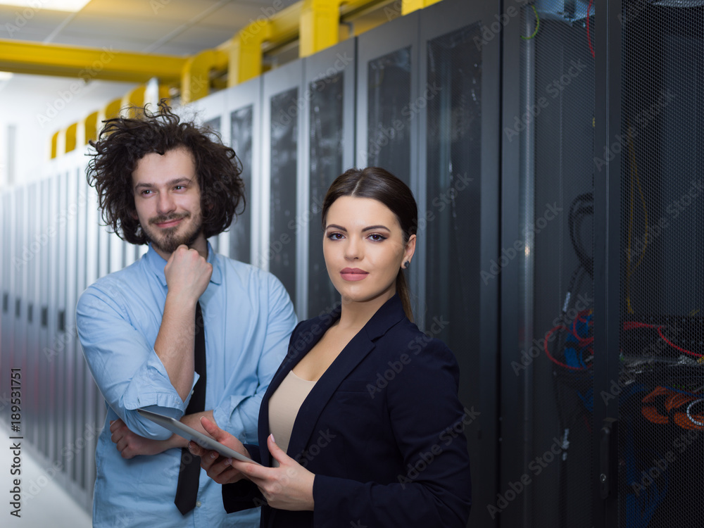 engineer showing working data center server room to female chief Stock ...