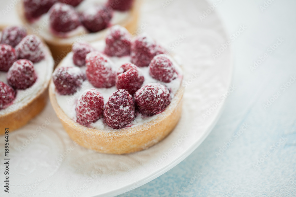 Delicious raspberry tartlets on a white vintage plate. Sweet treat on a ...