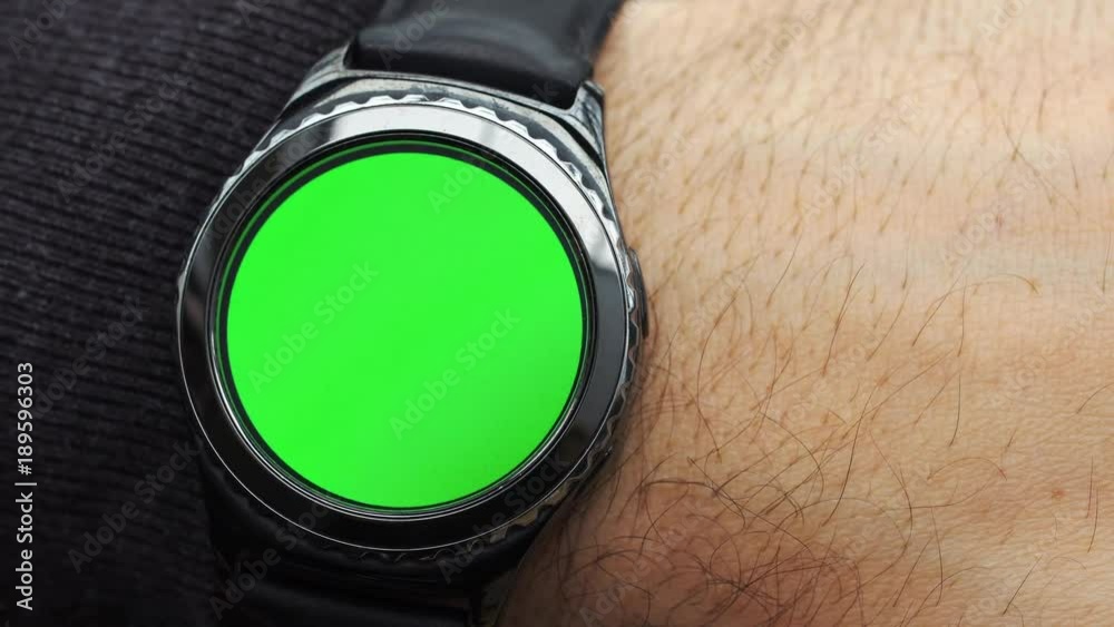 Man hands gestures on a round screen modern smartwatch with a green ...