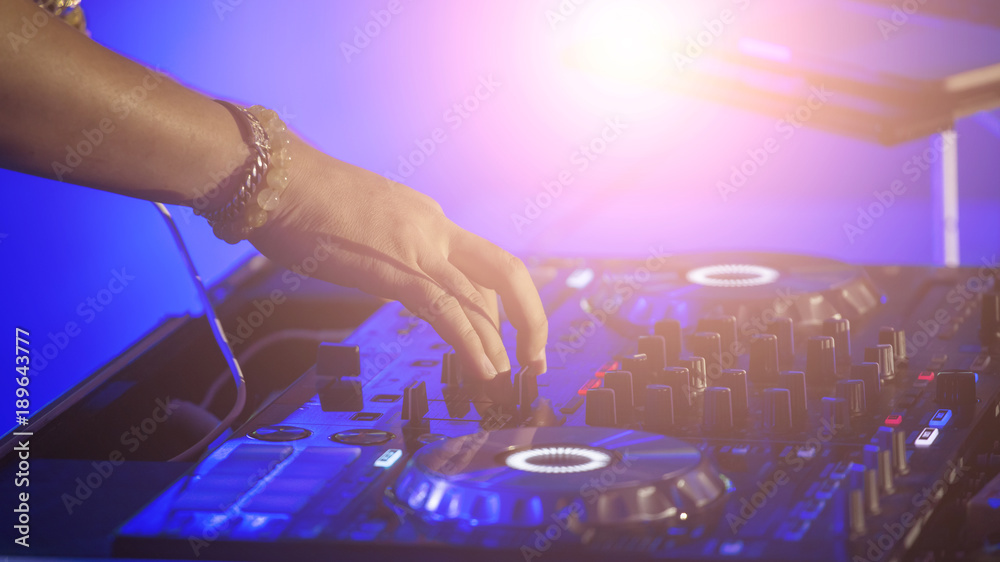 Charismatic disc jockey at the turntable in concert. DJ plays on the ...