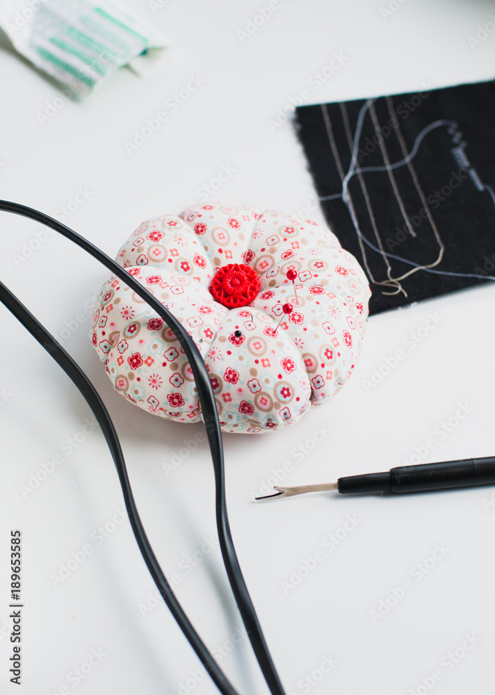 Colorful Pin Cushion With Red Button In The Middle And Stitch Thread