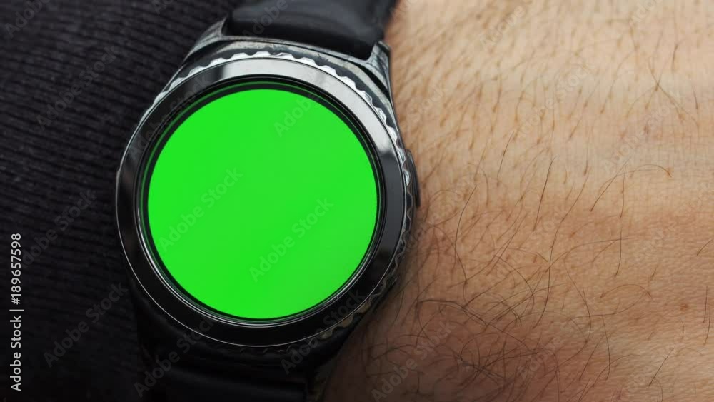 Man hands gestures on a round screen modern smartwatch with a green ...