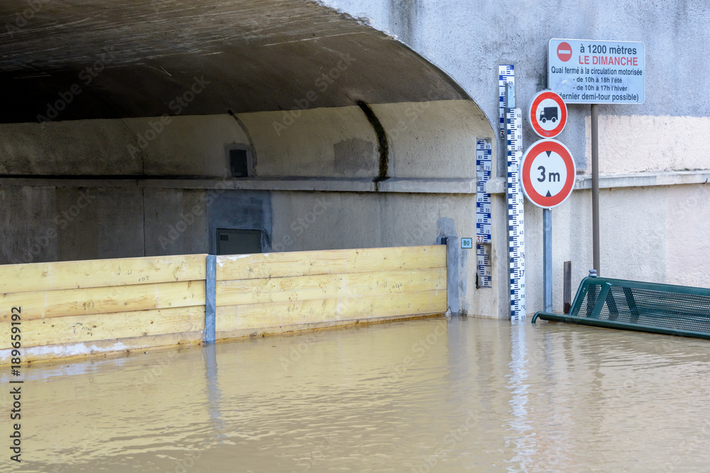 Flood markers and road signs at the entrance of a tunnel flooded by the ...
