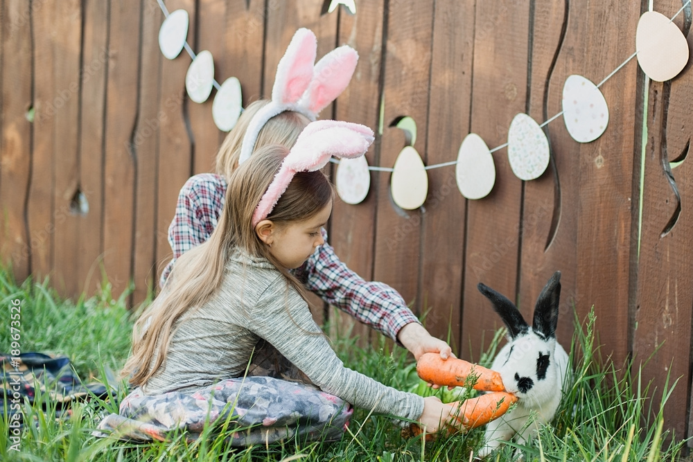Children play with real rabbit. Laughing child at Easter egg hunt with ...