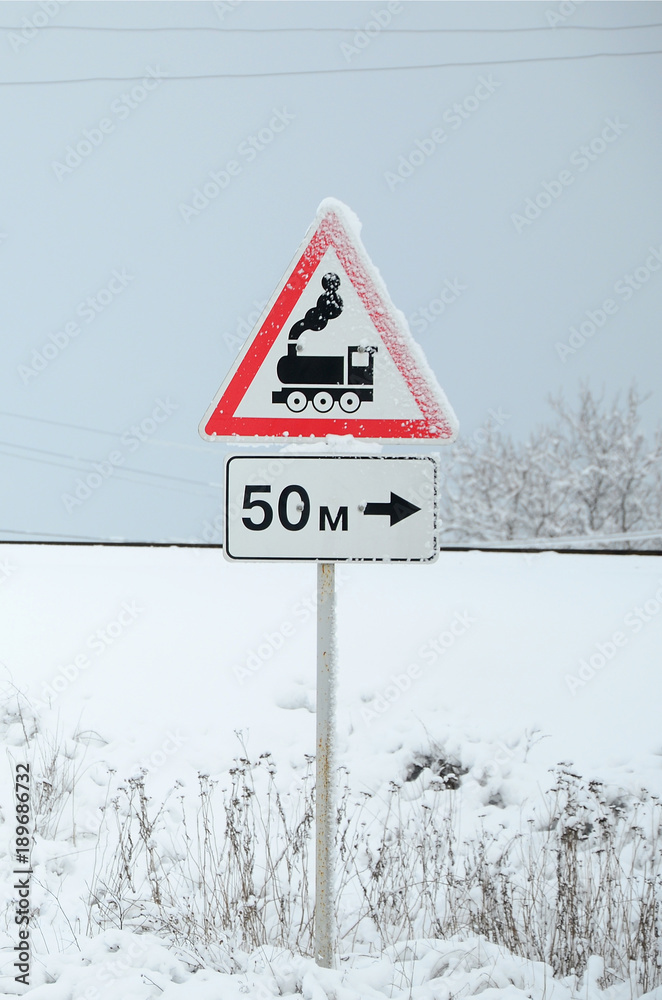 Railway crossing without barrier. A road sign depicting an old black ...