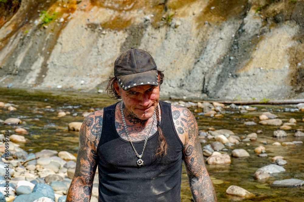 Dirty Tattooed Man With Smug Look On His Face, Standing Down At The ...