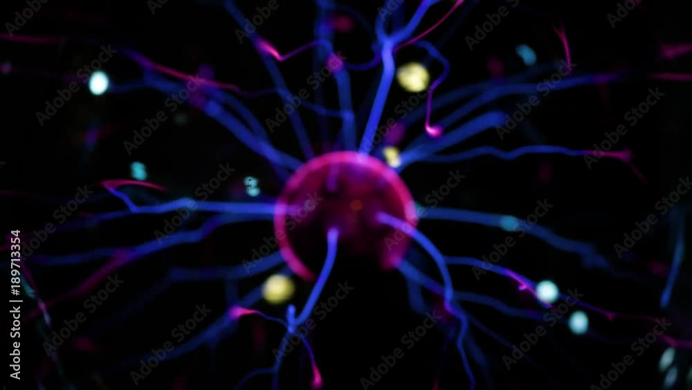 Closeup view of plasma ball with moving energy rays inside on black ...