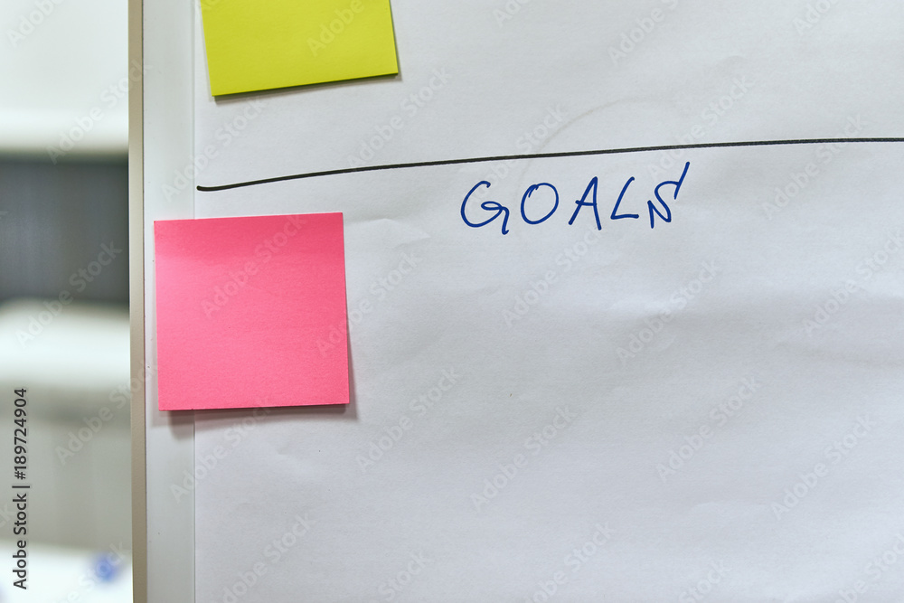 Word goals together with pink and yellow paper stickers attached to a ...