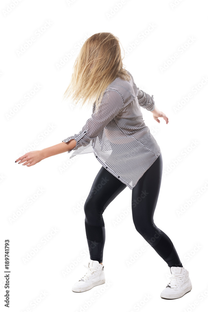 Side view of young funky blonde woman dancing with hair flowing over ...