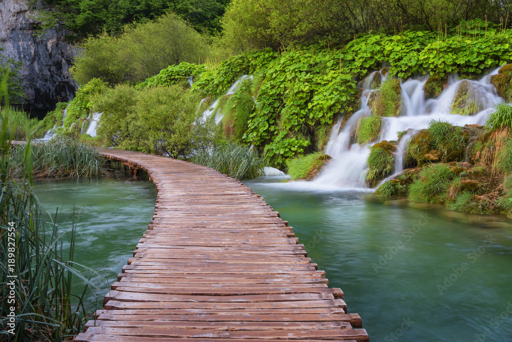 Beautiful view of waterfalls with turquoise water and wooden pathway ...