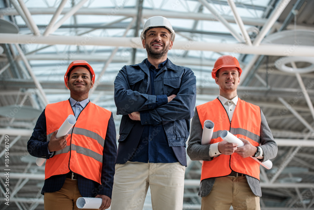 Professional team. Low angle portrait of joyful young builders are ...