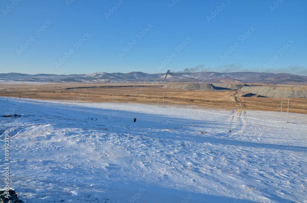 black smoke over coal mining site town Sagan Nur and waste piles ...