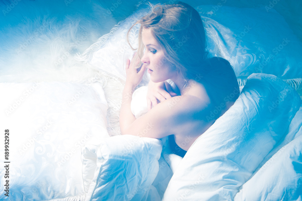 Dreamy girl lies in bed. Blonde in bed. The girl under the scoundrel ...