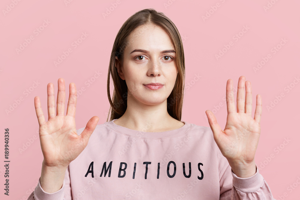 Pretty young woman with long dark staight hair shows stop sign, refuses ...