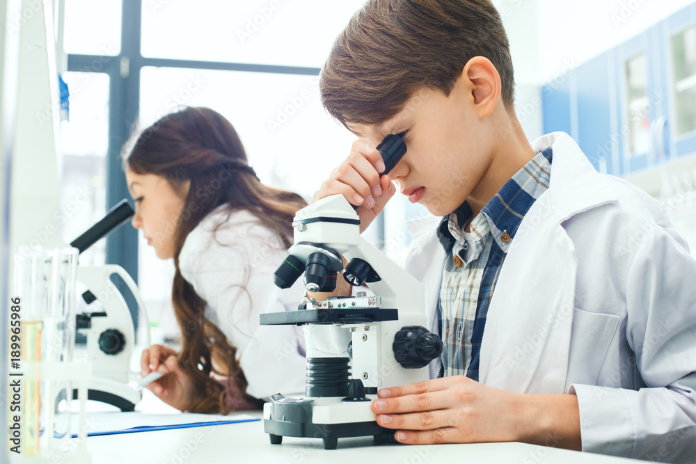 Little kids learning chemistry in school laboratory microscope project ...