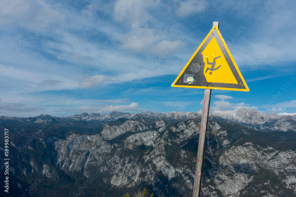 Warning sign for falling off a cliff or mountain. There are mountains ...