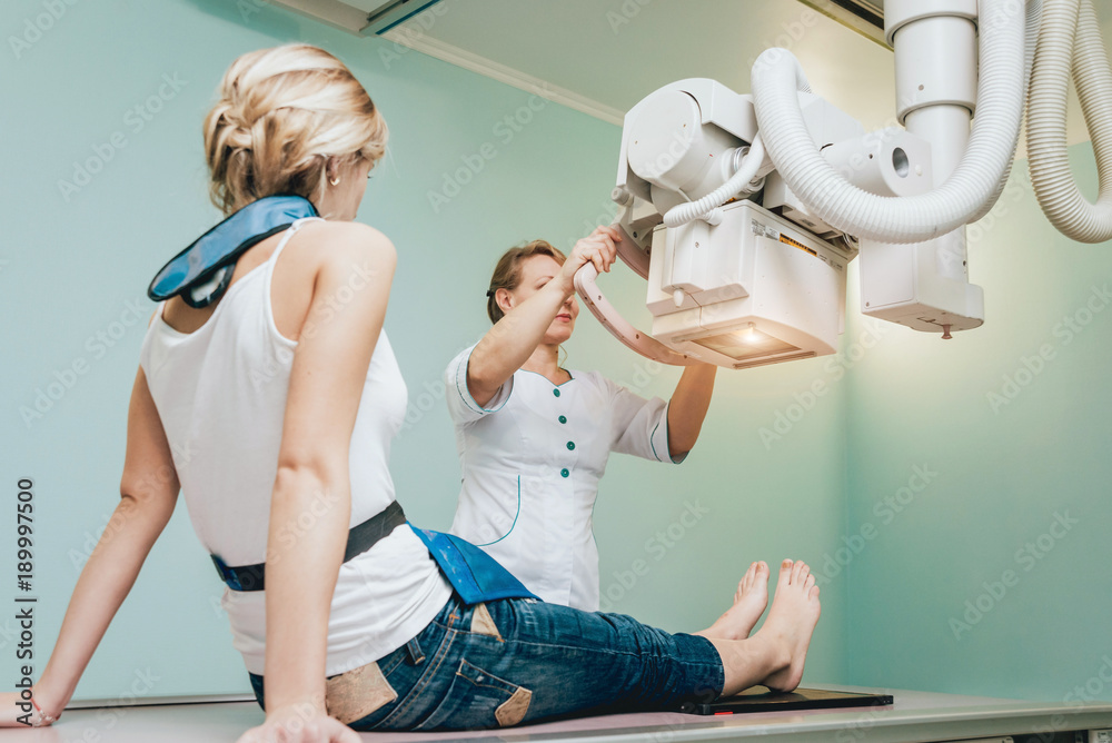Radiologist and patient in a x-ray room. Classic ceiling-mounted x-ray ...