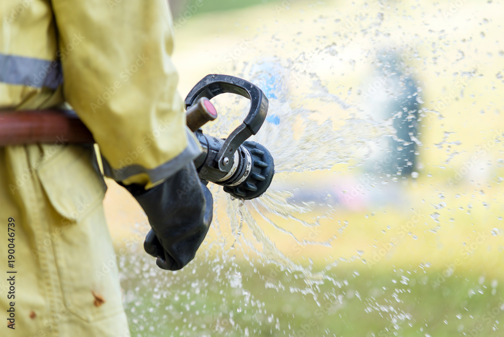 Firefighter holding high pressure fire hose nozzle. Firefighters ...