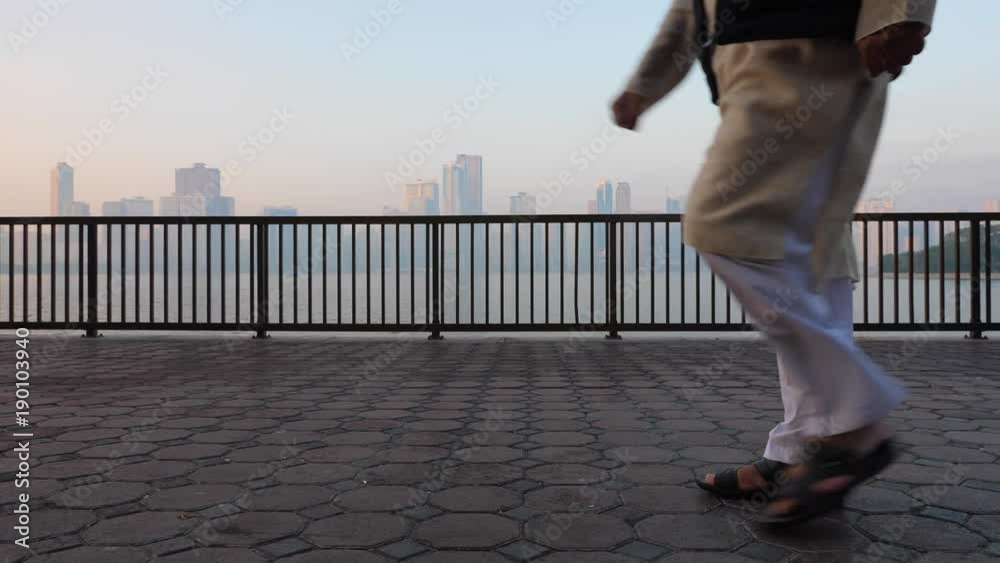 Arabian man walk through quay. Close up view legs in sandals walking by ...