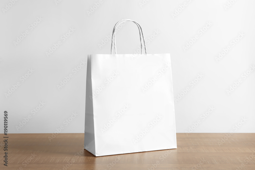 Paper bag on table against white background. Mockup for design Stock ...