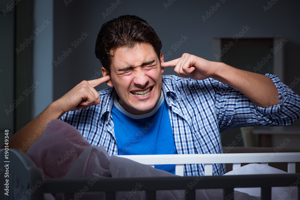 Young father under stress due to baby crying at night Stock Photo ...