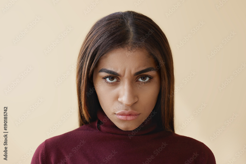 Close up studio portrait of grumpy angry young African American ...