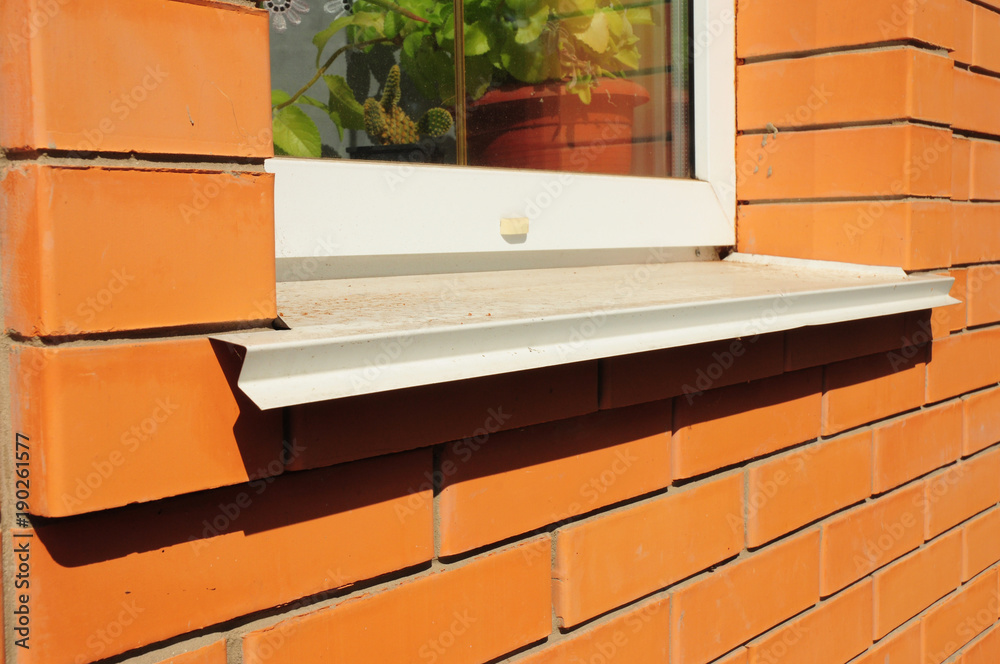 Install white metal window sill on the brick house. Stock Photo | Adobe ...