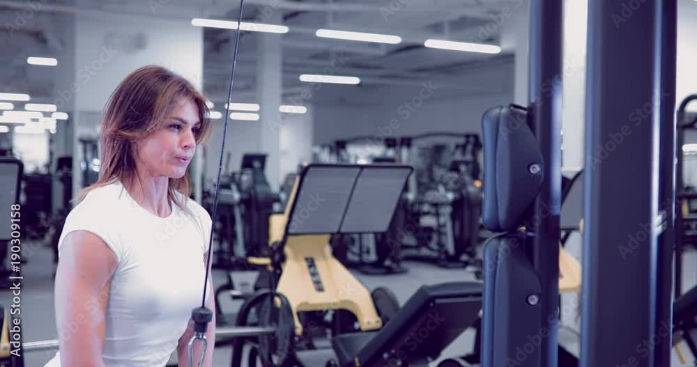 Adult woman doing Exercises for Tricep in fitness gym. Beautiful Woman ...