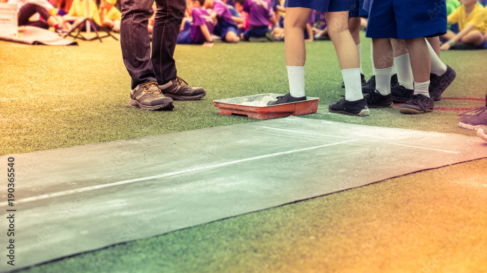 Students boy prepare for long jump competition at school sports day by ...