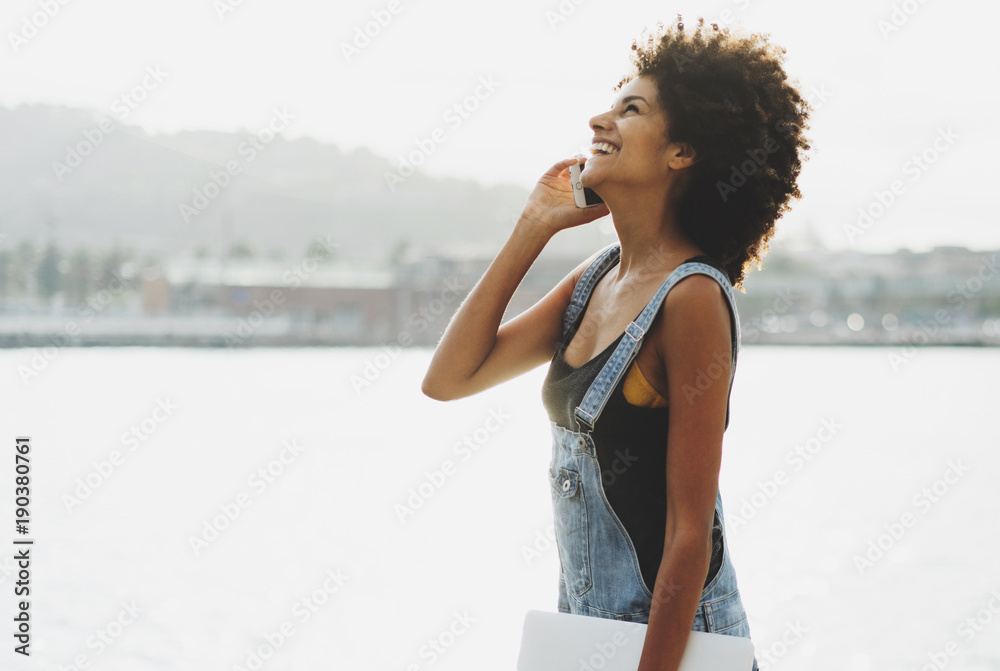 beautiful model looking dark-skinned girl laughing while talking on a ...