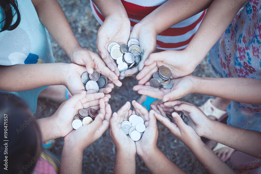 Group of children holding money in hands in the circle together as ...