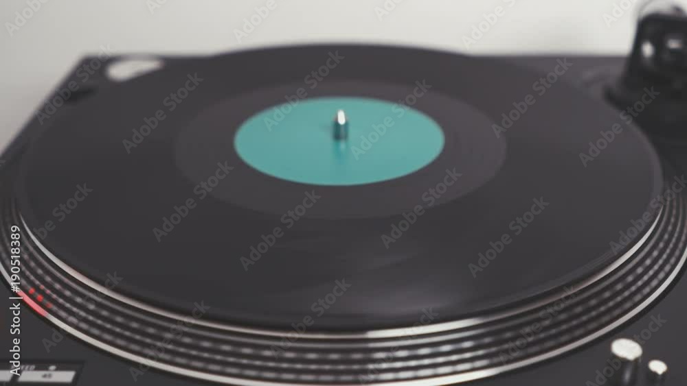 Turntable vinyl record player. Hand man puts a vinyl record, and ...