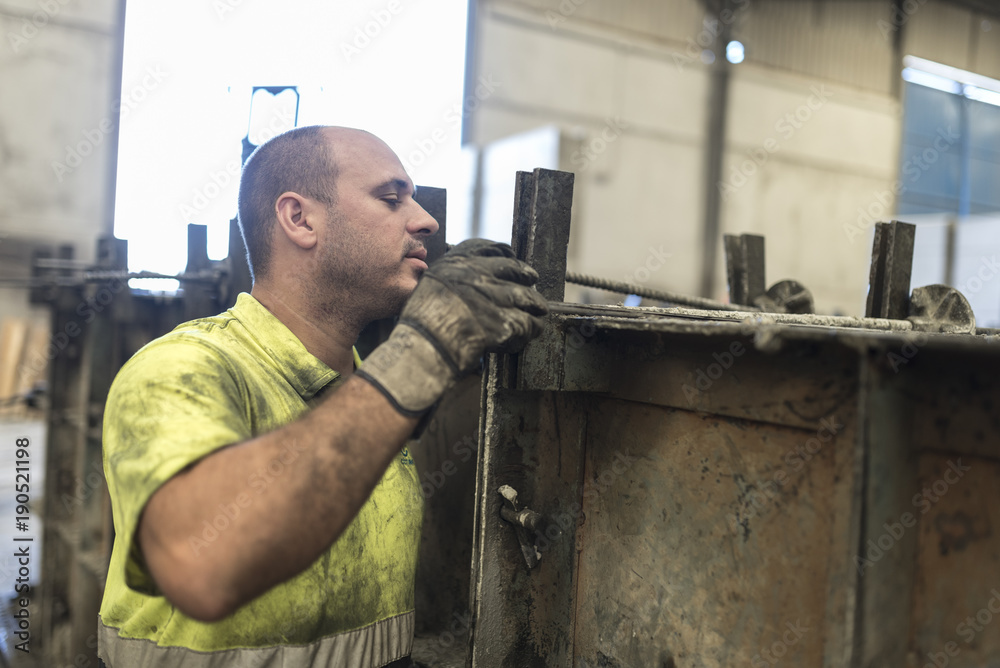 Man adjusting and measuring concrete structure in construction factory ...