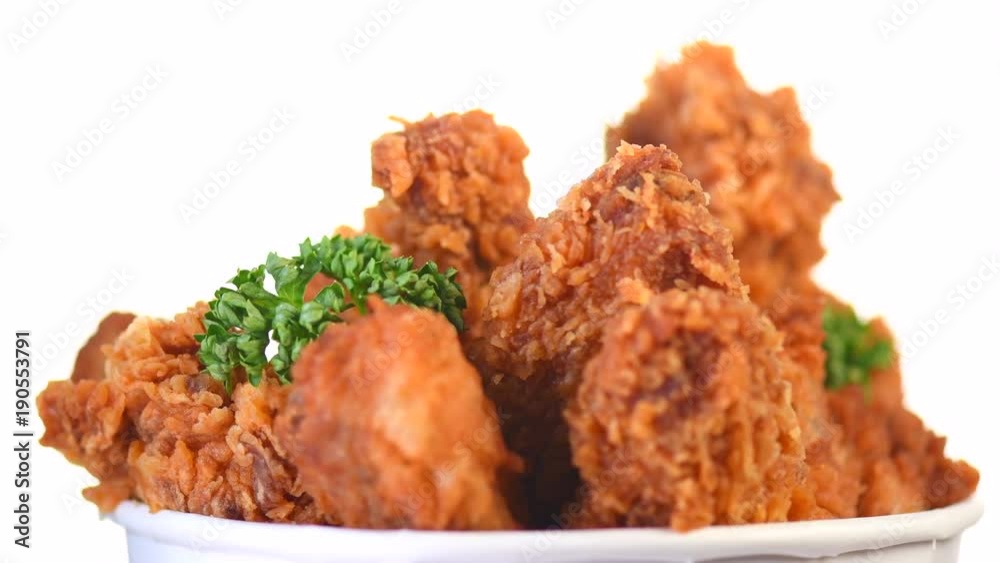 Bucket full of crispy fried chicken rotated on white background. 4K UHD ...