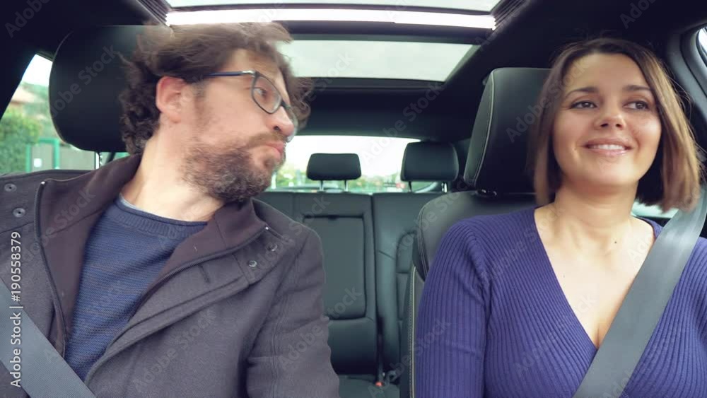 Cute happy couple in love in car kissing while driving slow motion ...