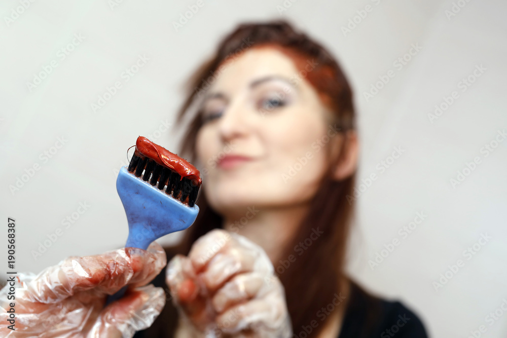 Process of hair coloring at home. Blue brush with red colour in focus ...