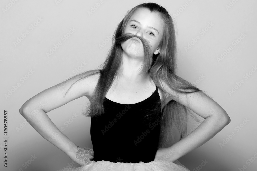 Beautiful little girl making mustache from her hair funny isolated on ...